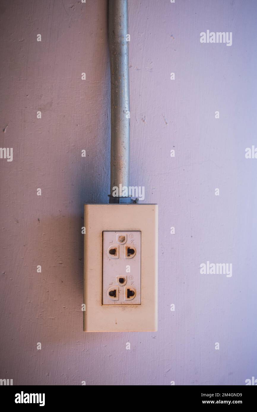 Plastic electric plug on concrete wall with steel tube Stock Photo - Alamy