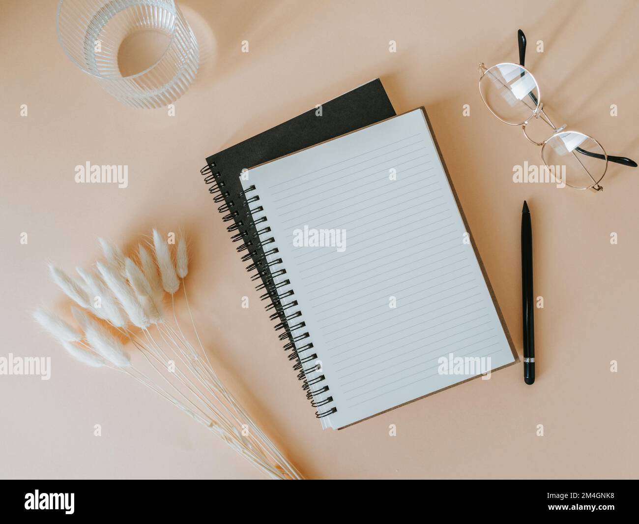 Flat lay blank paper sheet in notebook, dry flowers bouquet, glasses on ...