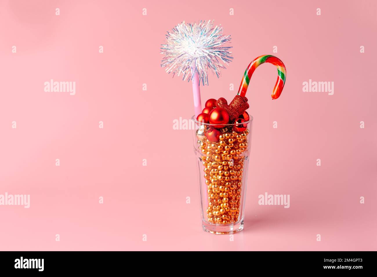 Glass with Christmas decorations on pink pastel background Stock Photo ...