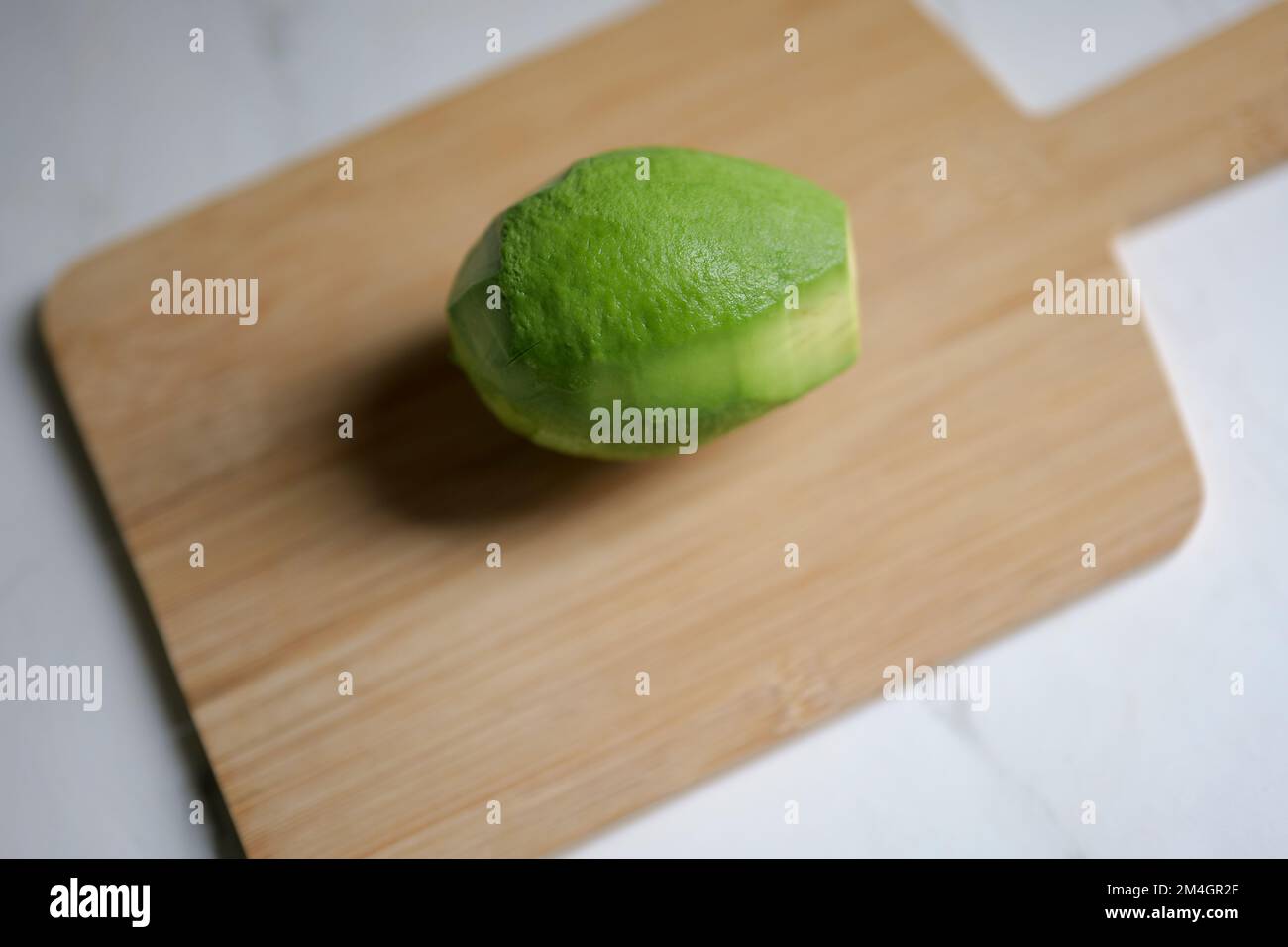 Selective focus on texture of peeled avocado on wooden cutting board on ...