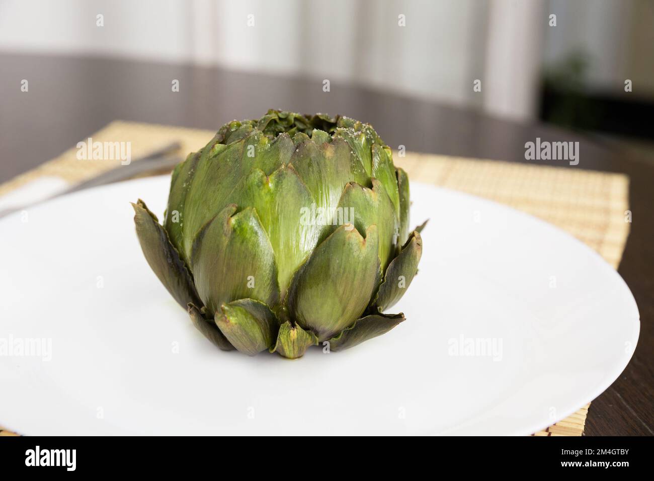 cooked whole artichoke on a white plate Stock Photo - Alamy