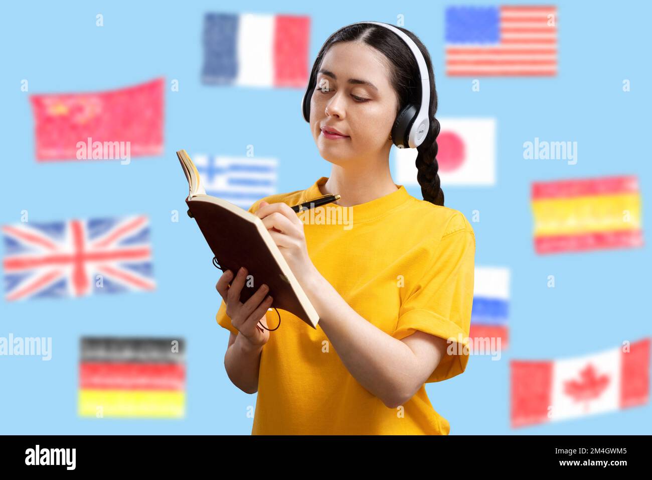 Language learning. A young beautiful Caucasian woman with headphones is ...