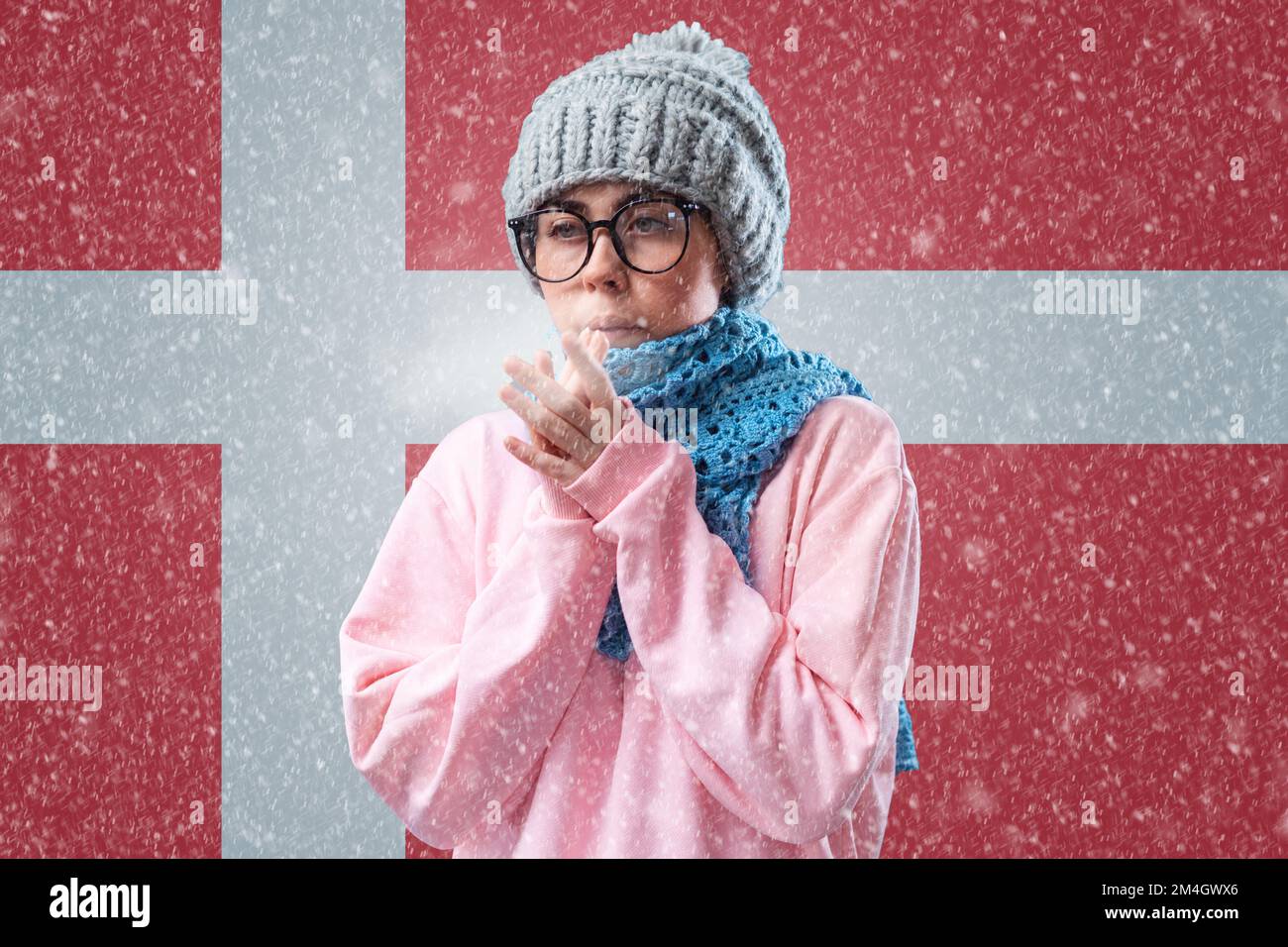 Energy crisis in Europe. Danish woman in hat and scarf is breathing and ...