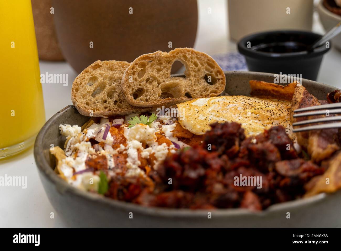 bacon with egg plate with frying pan, with orange juice, toasted bread ...