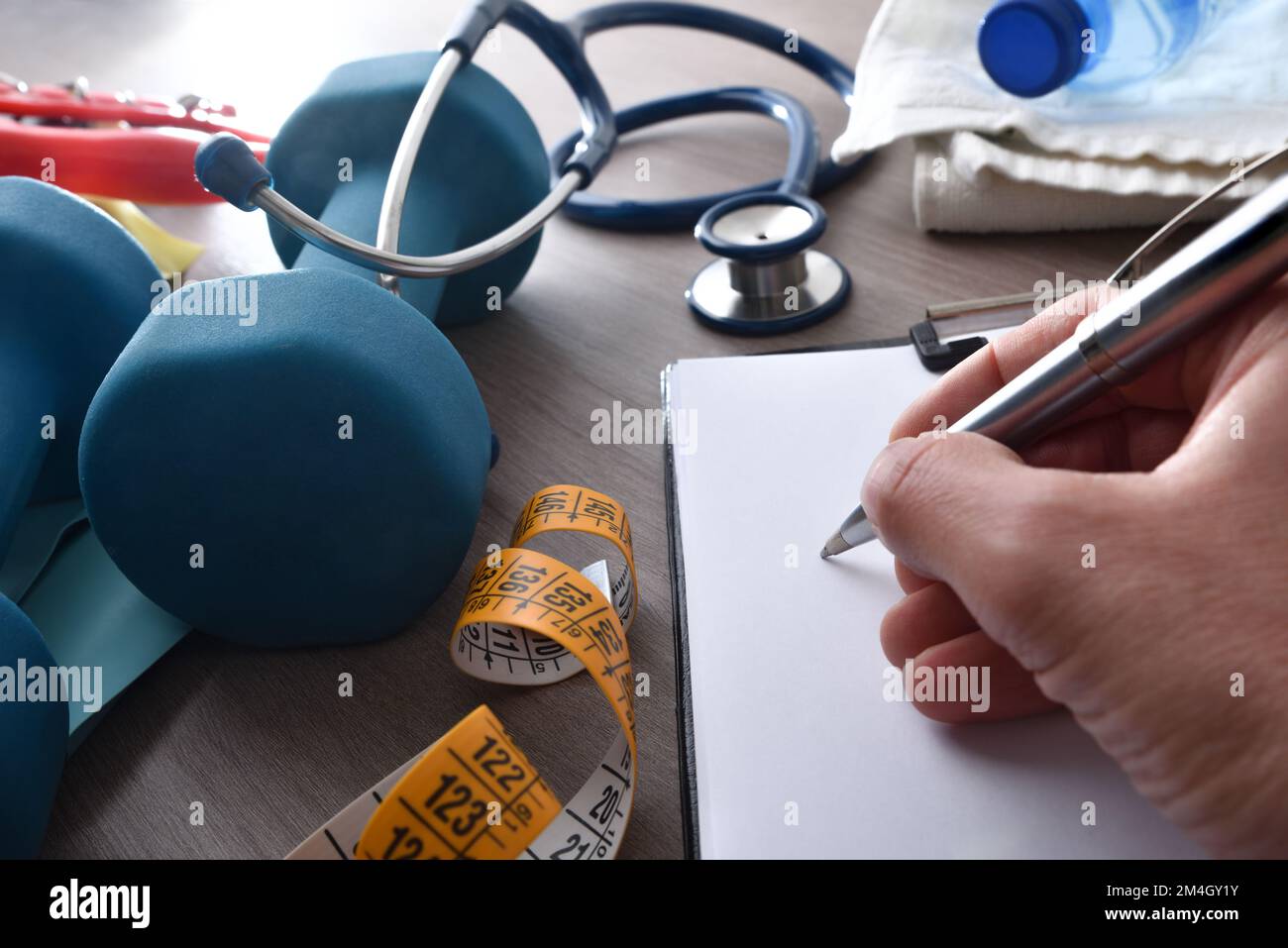 Physiotherapist doctor taking notes on office table with medical ...