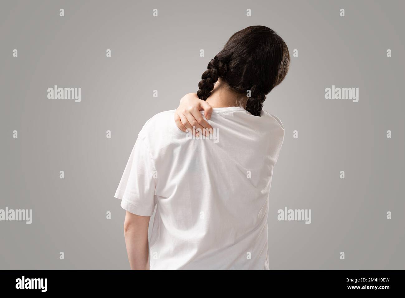 Arthritis and chondrosis. Woman with piggy tails holds her shoulder ...
