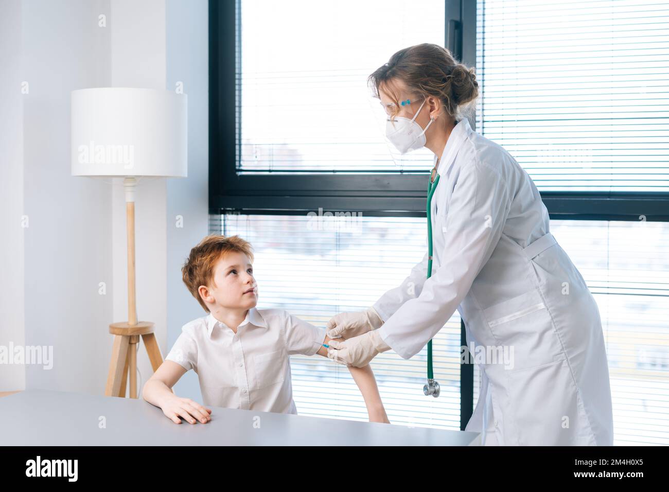Portrait of female pediatrician wearing white uniform applying plaster ...