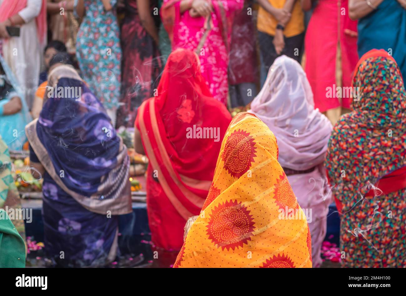 women devotees standing in river and praying for sun god in Chhath ...