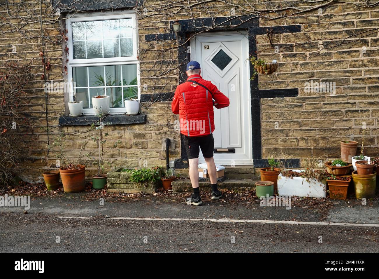 A postman delivering mail to a house Stock Photo - Alamy