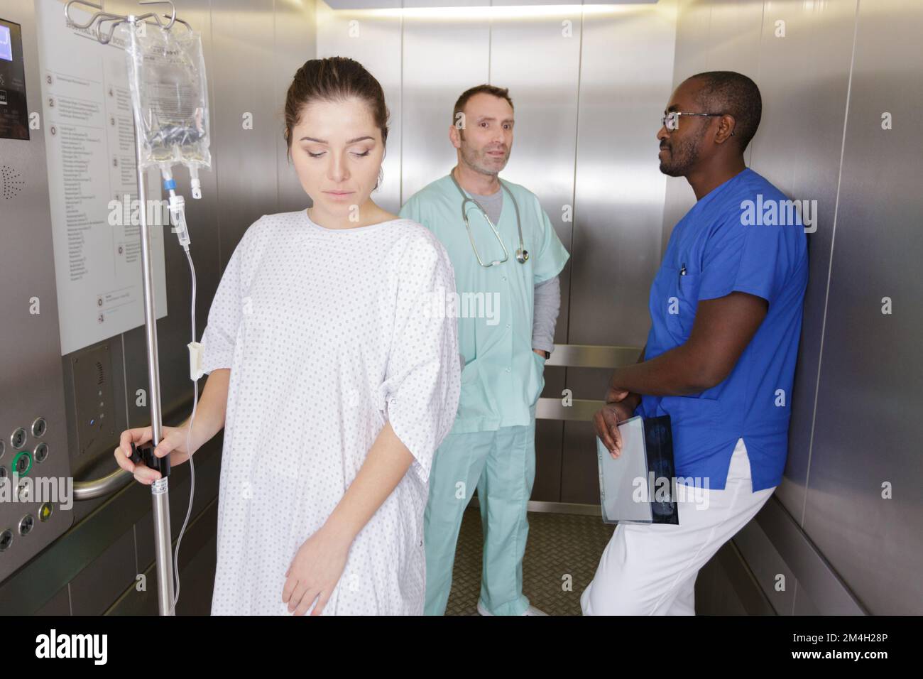 patient with drip in elevator with nurse and doctor Stock Photo - Alamy