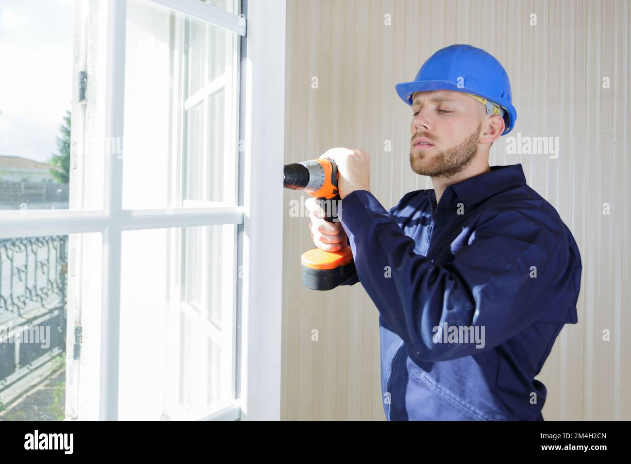 construction worker using drill to install replacement window Stock ...