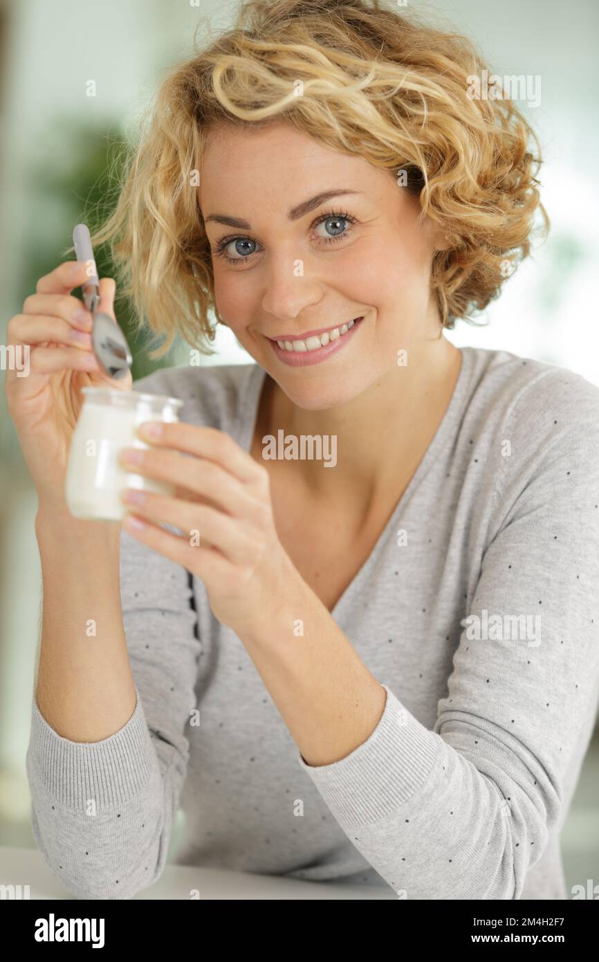 young smiling woman eating yogurt Stock Photo - Alamy