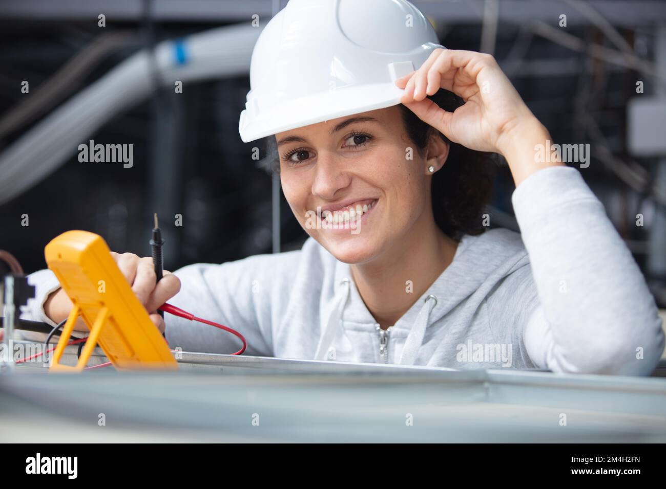 female electrician wearing white helmet in construction site Stock ...