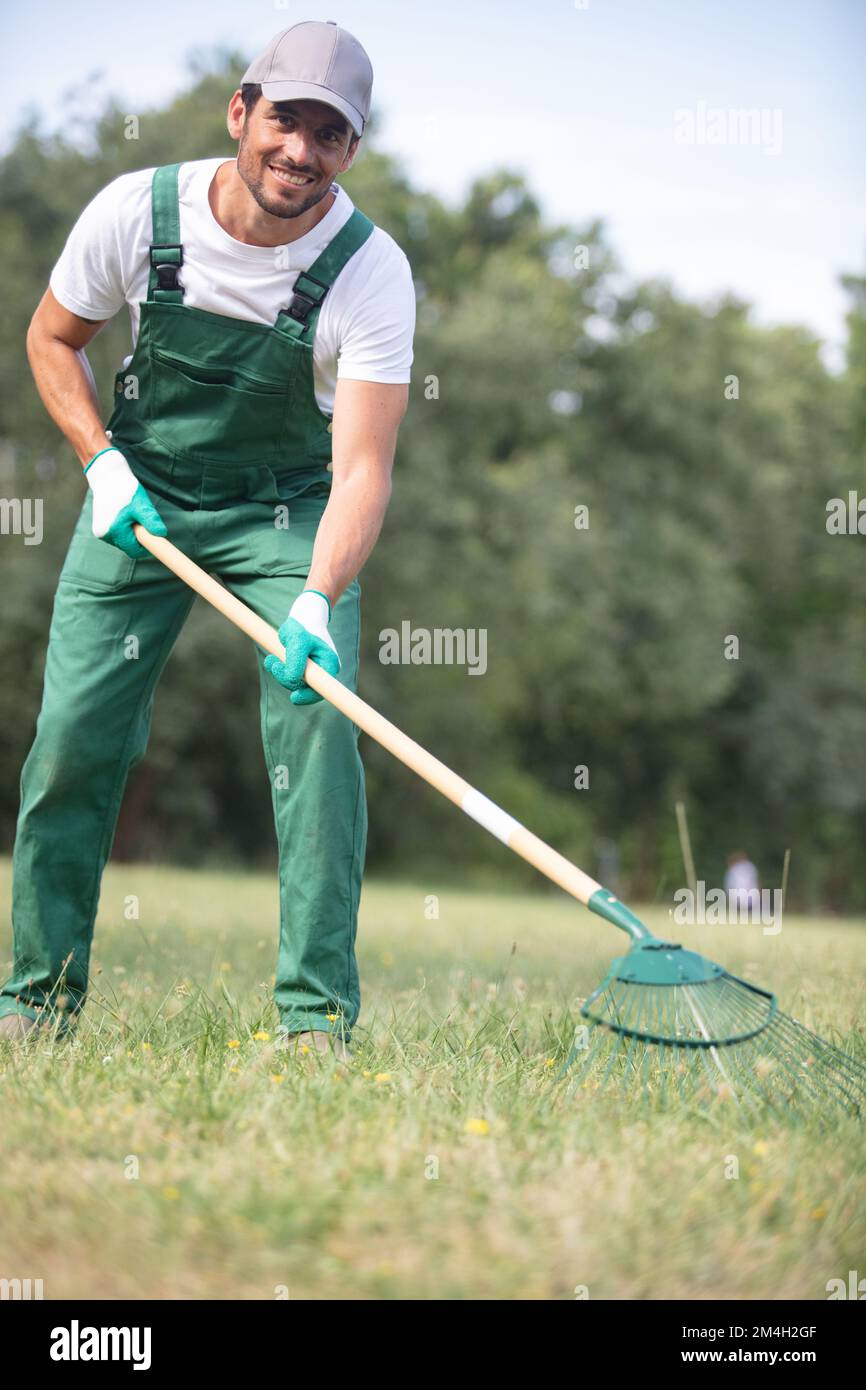 happy farmer holding a rake Stock Photo - Alamy