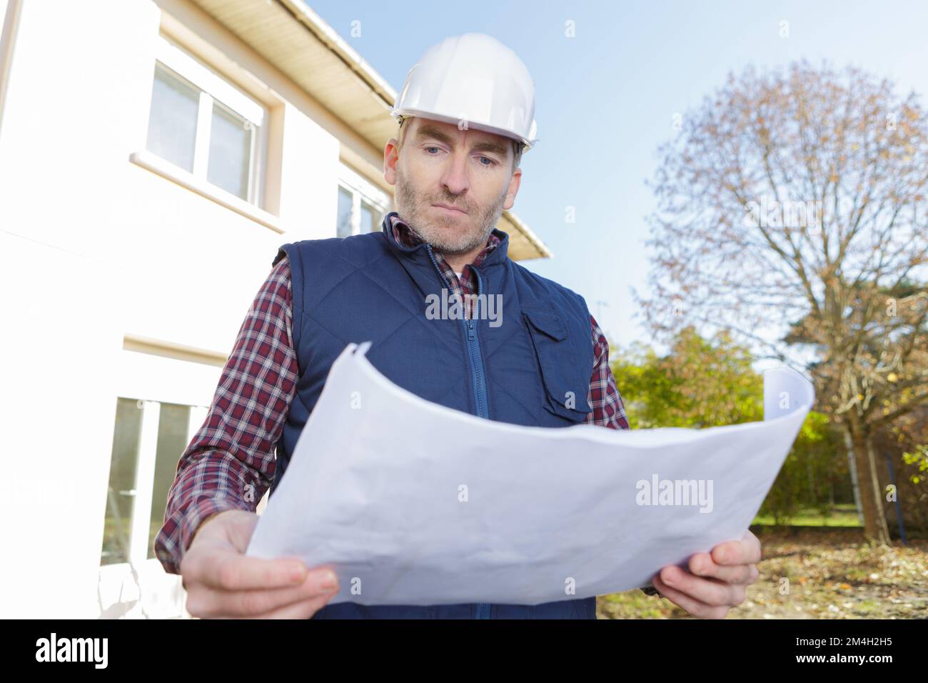 foreman construction worker looking at blueprint Stock Photo - Alamy