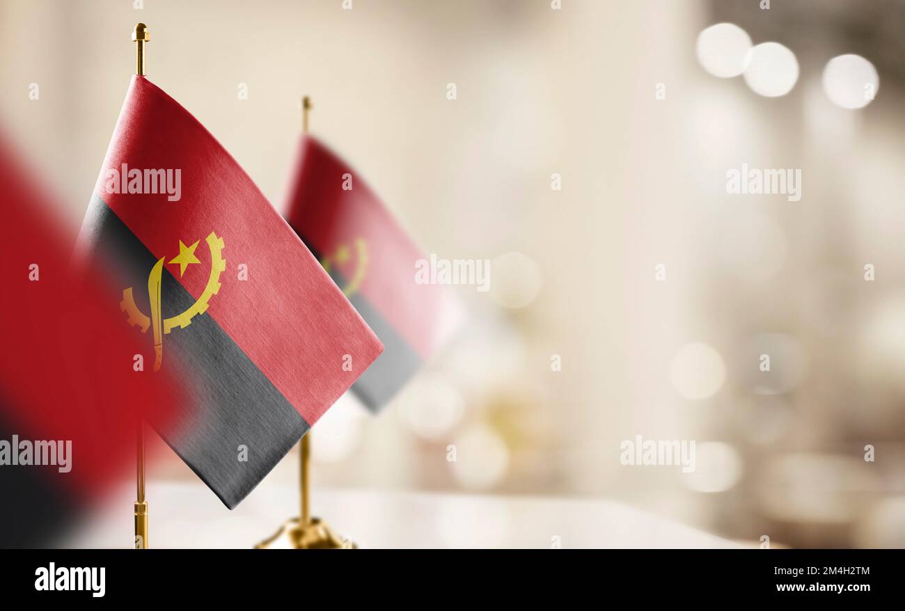 Small flags of the Angola on an abstract blurry background Stock Photo ...