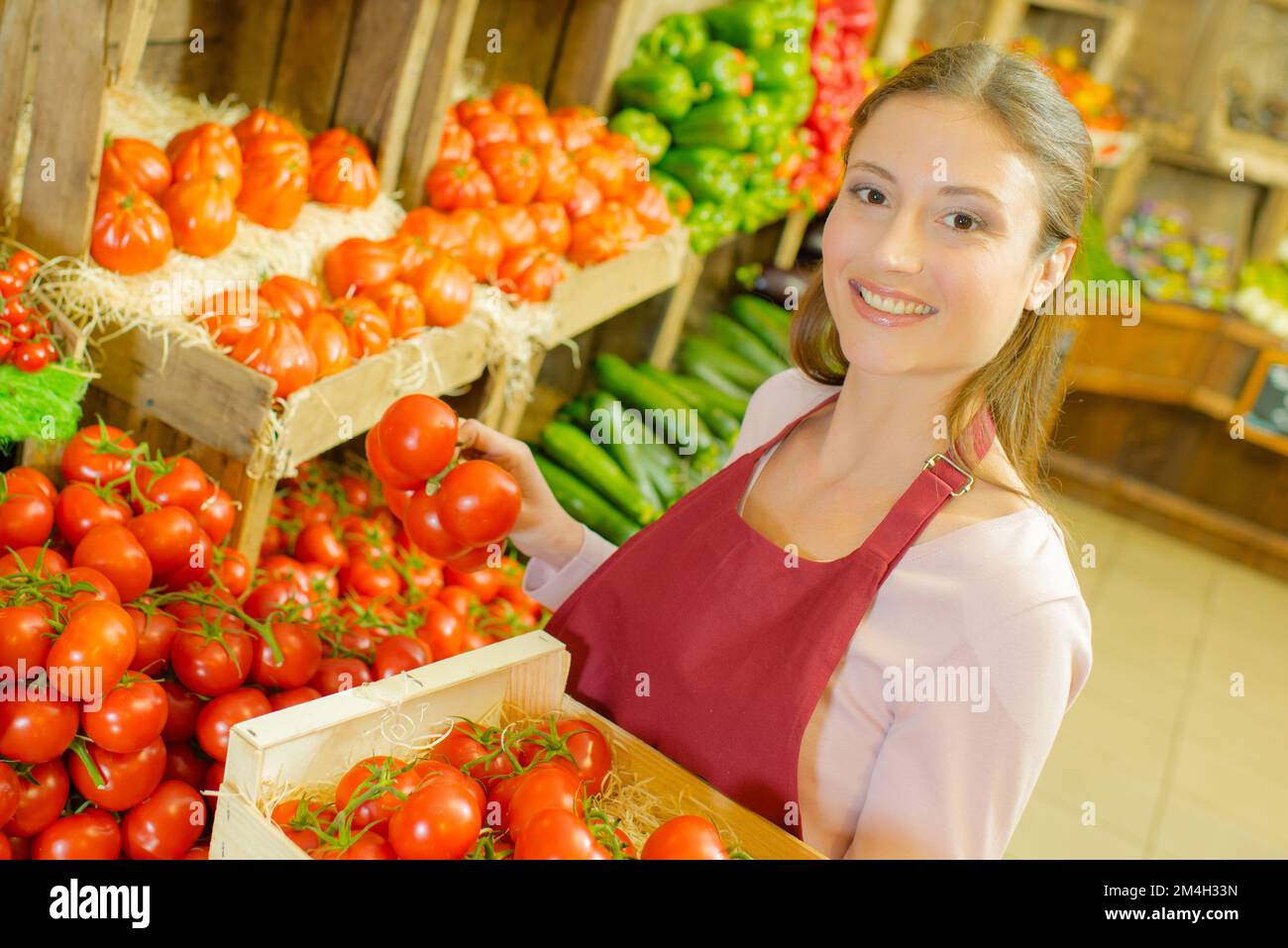 Shop assistant restocking tomato display Stock Photo - Alamy