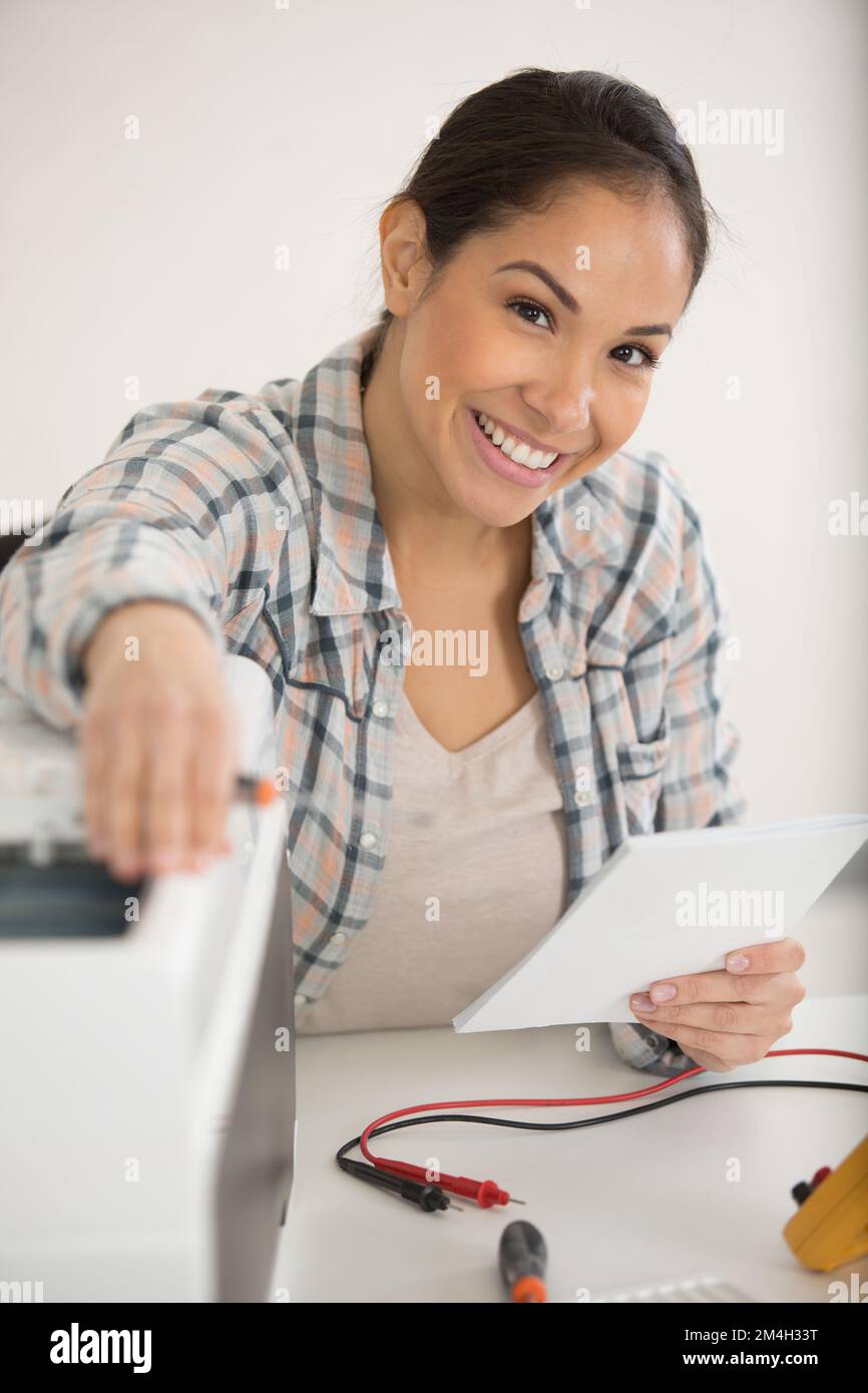 smiling woman is fixing a printer Stock Photo - Alamy