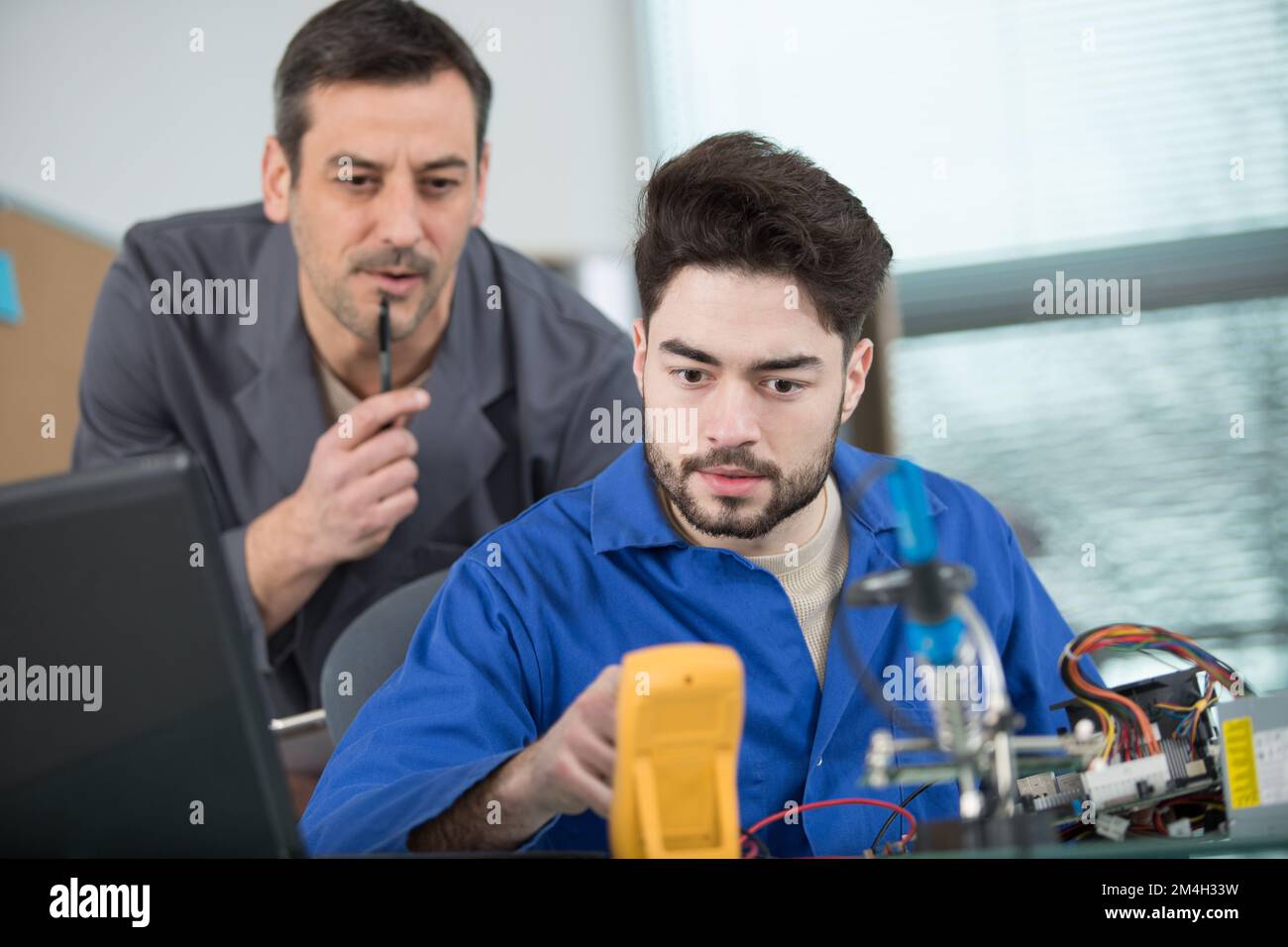 apprentice and teacher during engineering test Stock Photo - Alamy
