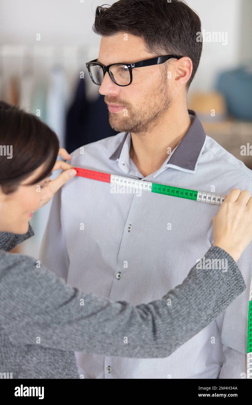 seamstress taking clients measurements in atelier Stock Photo - Alamy