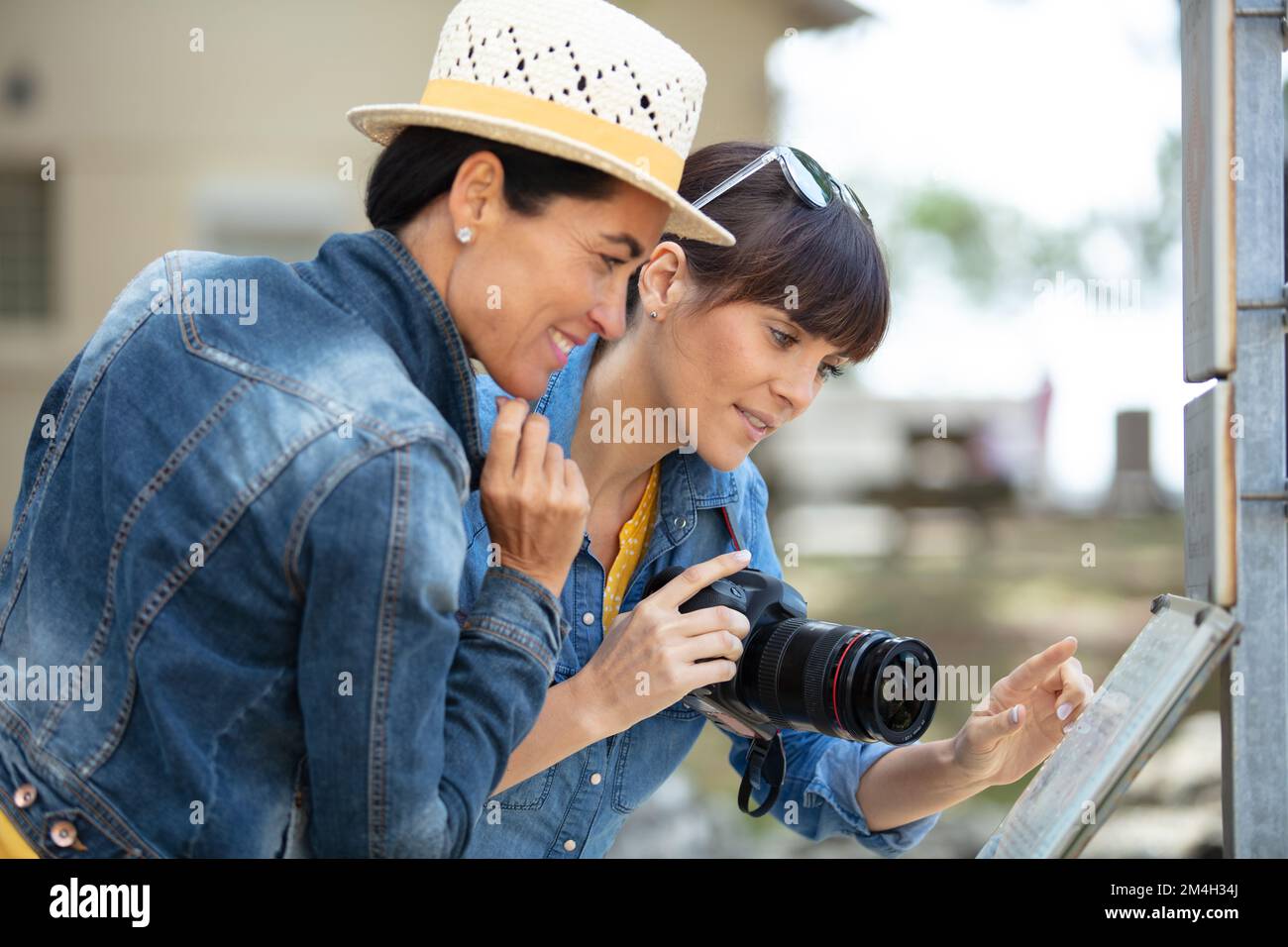 two tourists checking information on sign post Stock Photo - Alamy