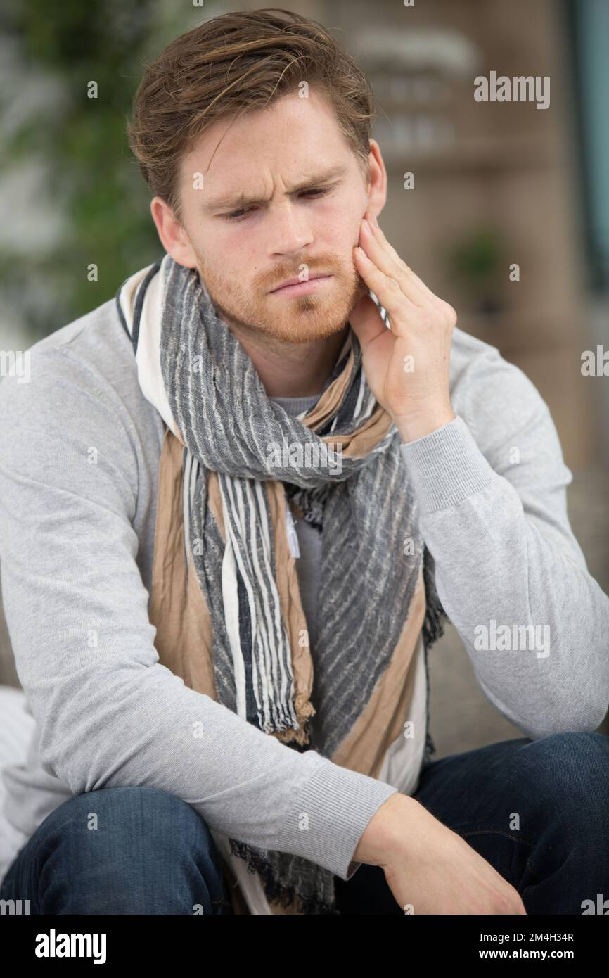 a young guy shows that his tooth hurts Stock Photo - Alamy