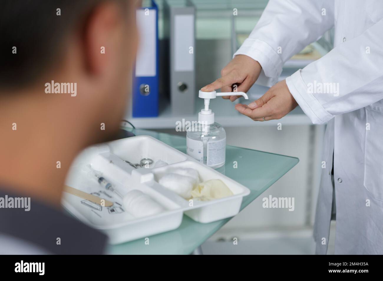 doctor pumping disinfectant into hand from dispenser Stock Photo - Alamy
