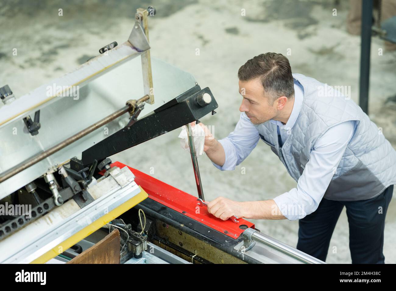 engineer wiping part of industrial machine with rag Stock Photo - Alamy