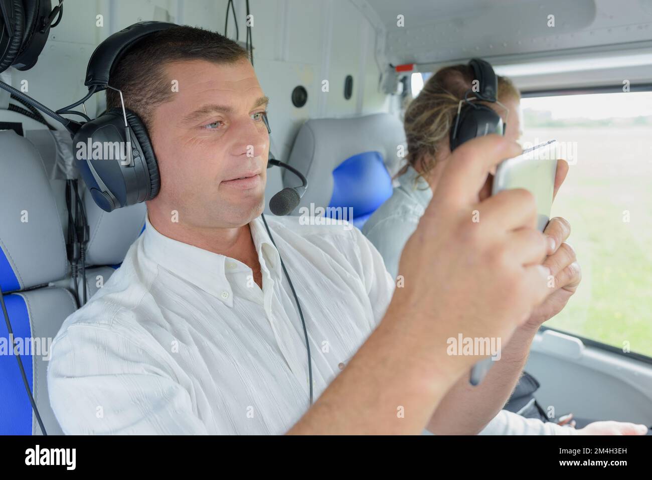 airline pilot taking pictures with smart phone in airplane cockpit ...