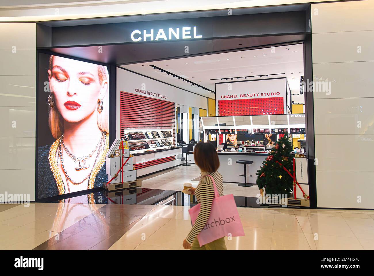 A woman walks past a Chanel store at Siam Paragon shopping mall in ...