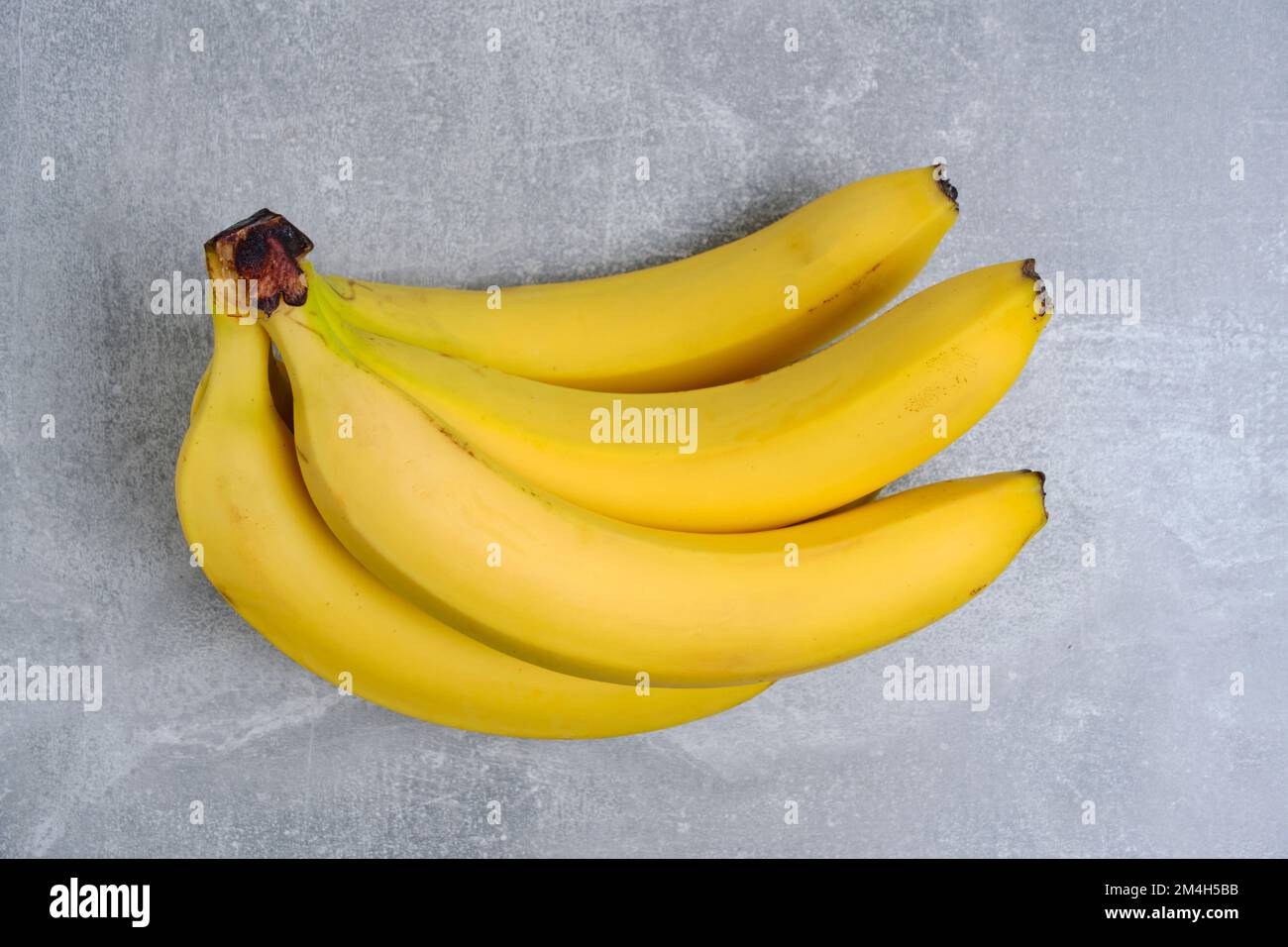 Bunch ripe, yellow bananas gray concrete background Stock Photo - Alamy