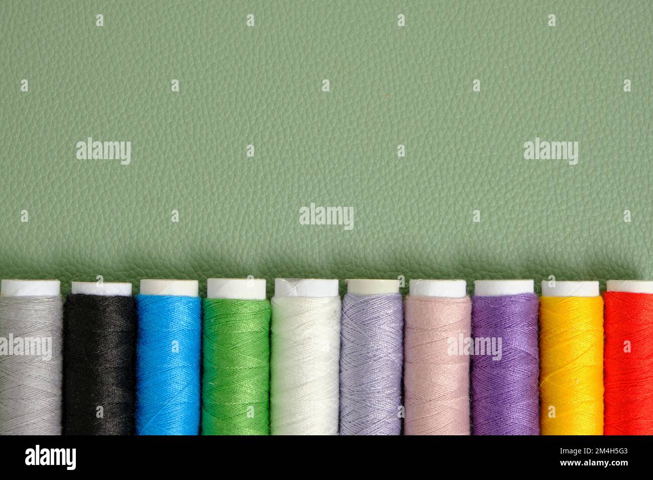 Reels with multi colored sewing threads green background Stock Photo ...