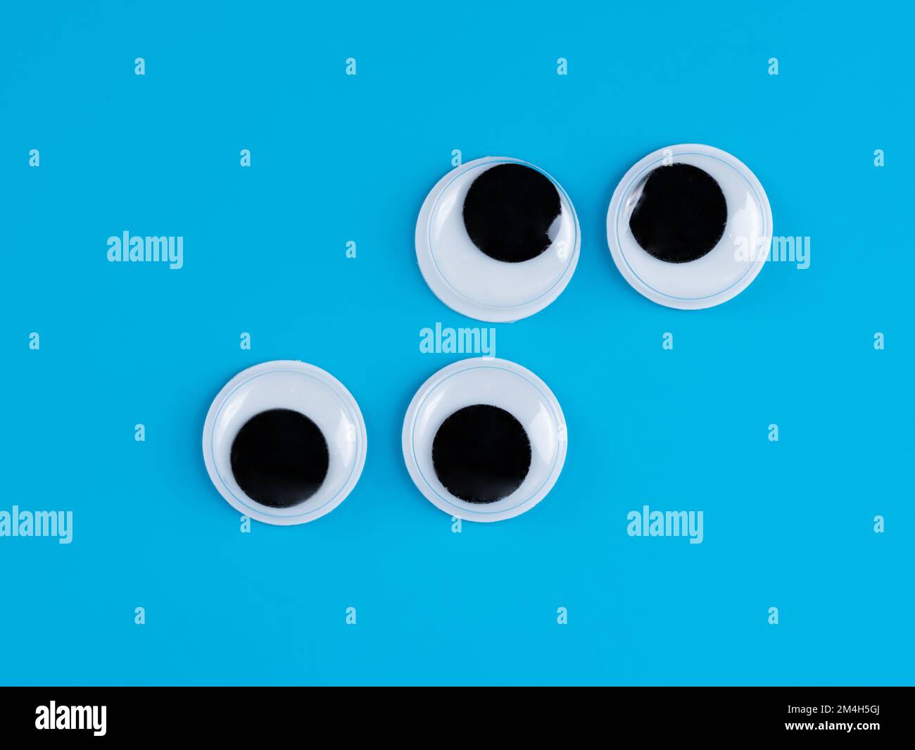 right offset pairs of googly eyes funny Isolated on light blue ...