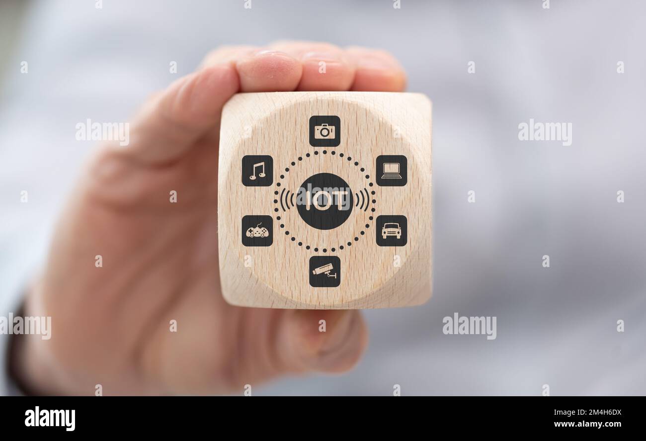 Hand holding a wooden cube with symbol of iot concept Stock Photo - Alamy