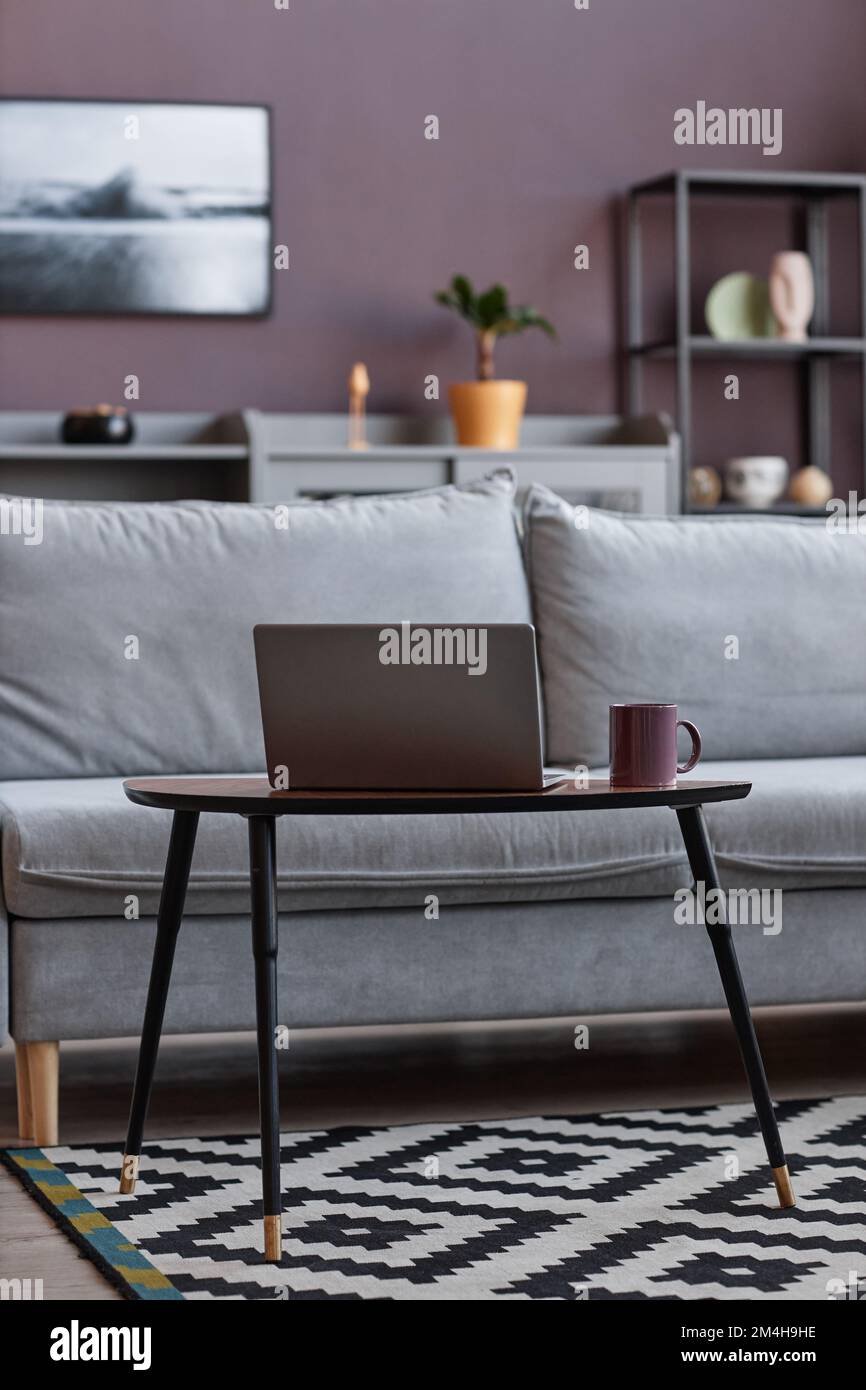 Vertical background image of open laptop by comfortable couch in ...
