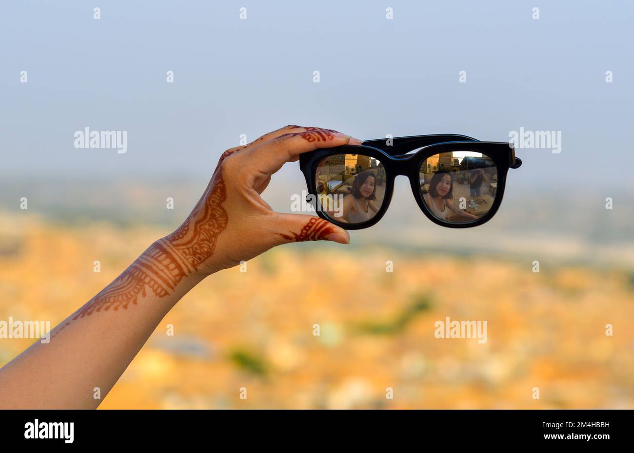 Woman hand holding sunglasses with old town background Stock Photo - Alamy