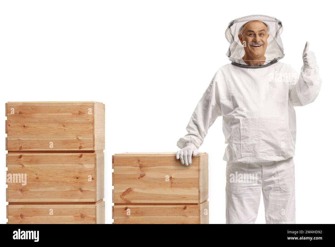 Bee keeper standing with wooden boxes and gesturing thumbs up isolated ...