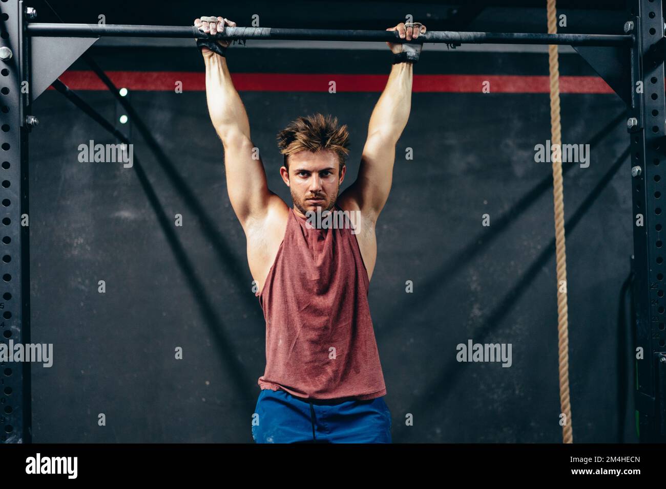 Concentrated fit man using a bar to do pull ups in a gym Stock Photo ...