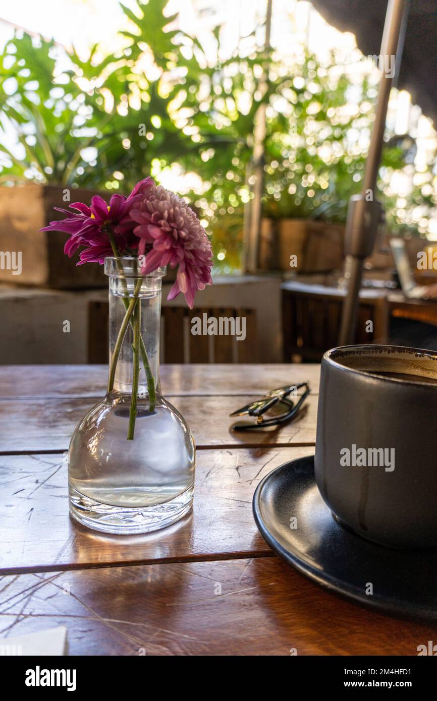 cup of coffee with black clay, wooden table, vegetation in the ...