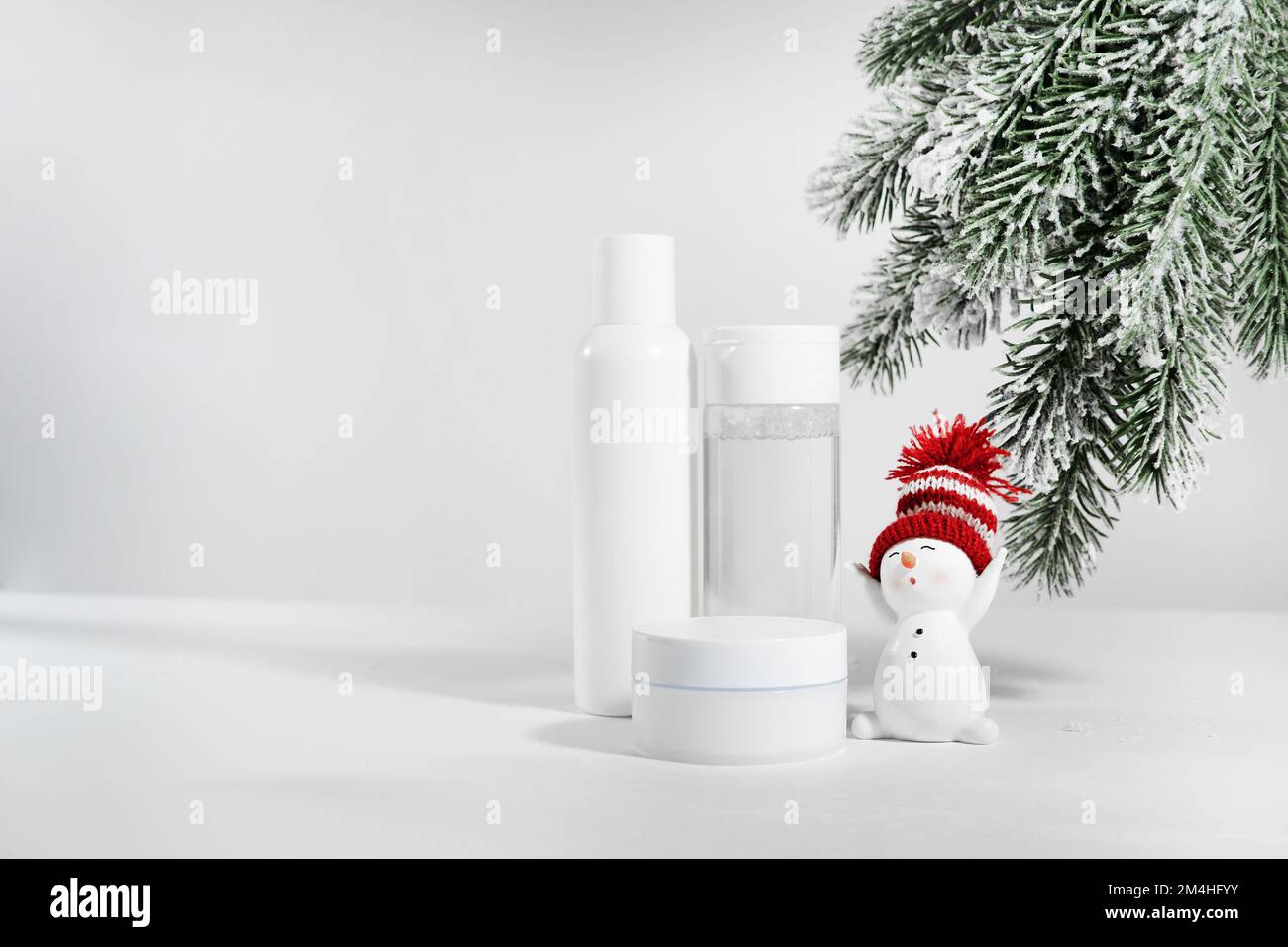 White jar of skin care cosmetics on a white surface with a snowman ...