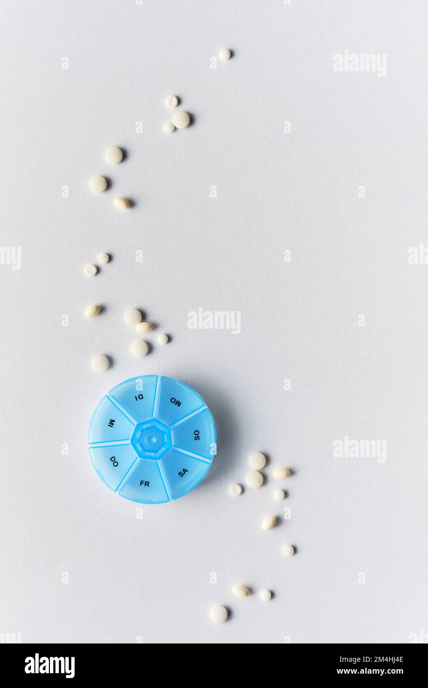 Tablet, pill dispenser and tablets. Flat lay, top view on off white ...