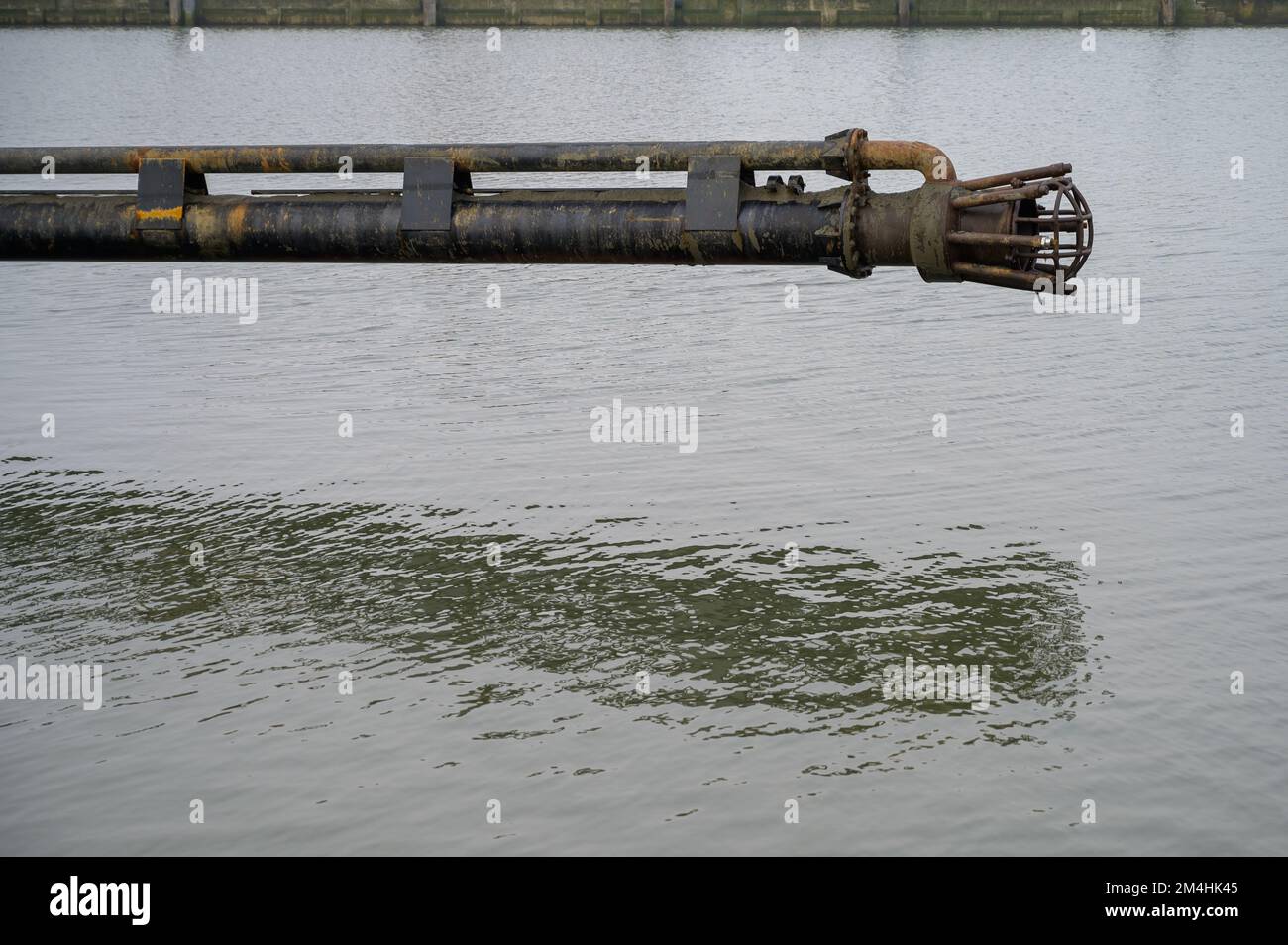 Side view of a dredge drag head of a suction dredge barge above water ...