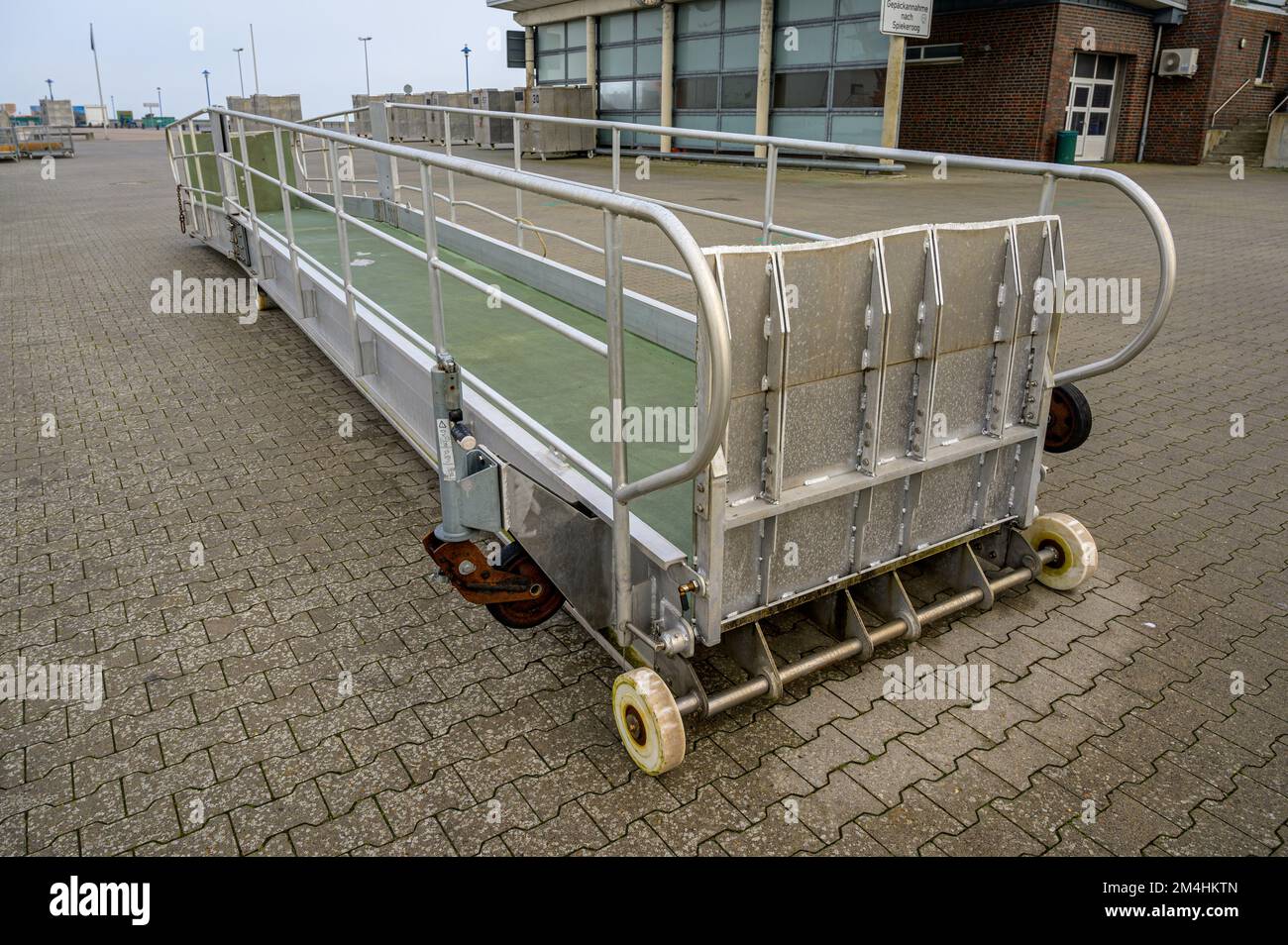 A silver passenger boarding ramp or gangway sits ready for use in a ...