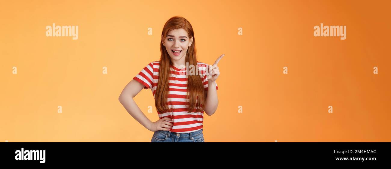 Lively friendly redhead woman discuss new trend pointing upper left ...