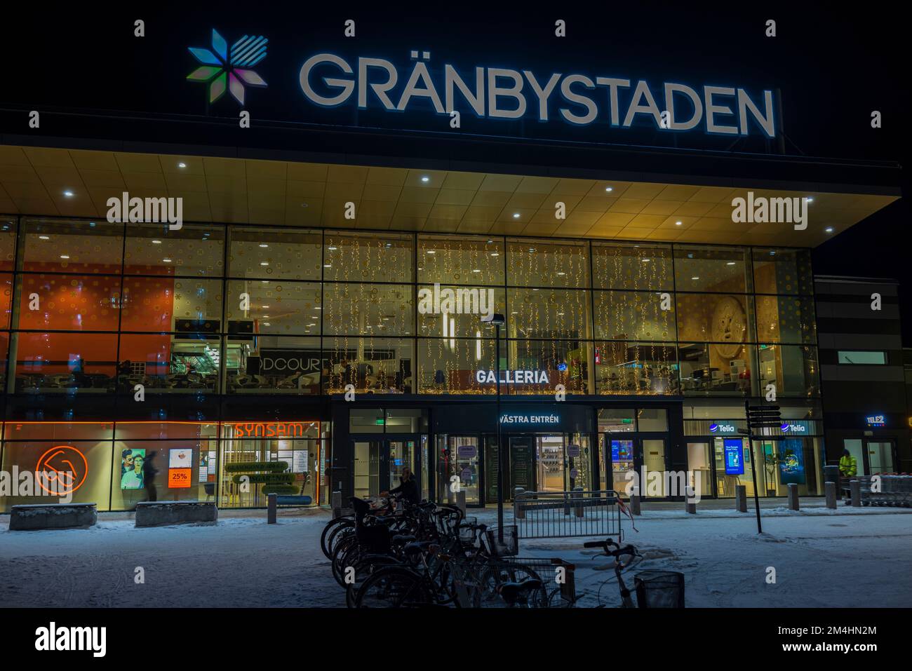 Winter view of square with bicycle parking in front of mall at night ...