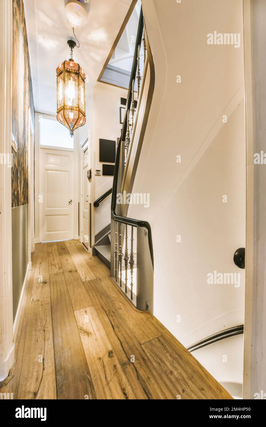 a hallway in a house with wood flooring and an old style light fixture ...