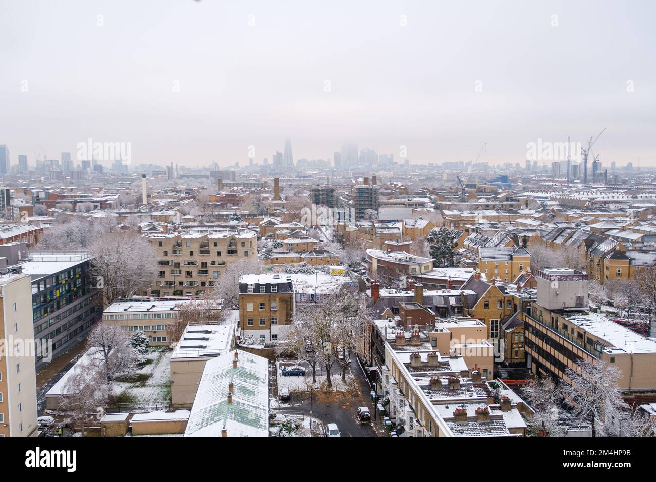 Aerial view of London rooftops covered in snow; the Shard and the City ...