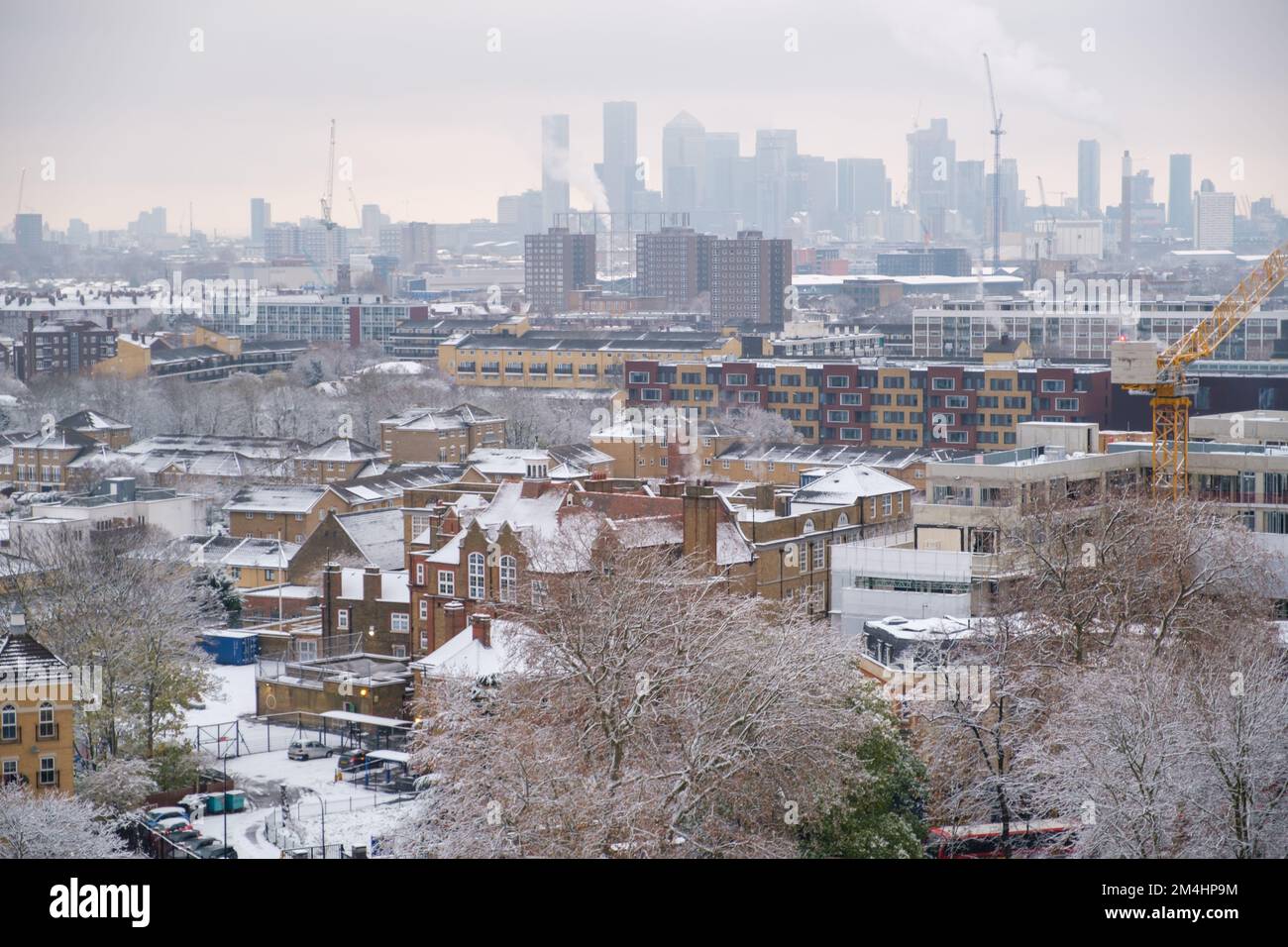 Aerial view of London rooftops covered in snow; Canary Warf in the ...