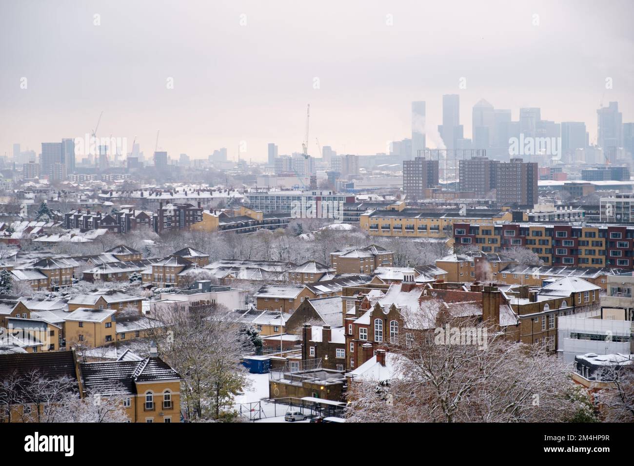 Aerial view of London rooftops covered in snow; Canary Warf in the ...