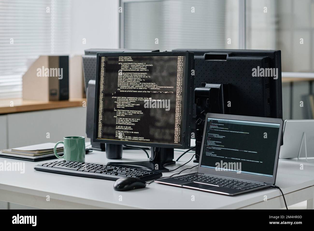 Workplace of developer with computer and laptop with codes on screens ...